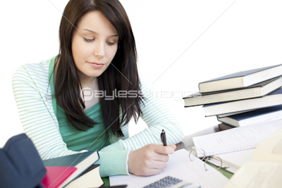 Positive student doing her homework on a desk - 商用利用可能な写真素材・イラスト素材なら ...